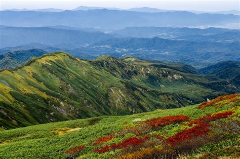月山へ続く緑の稜線と麓に広がる街の遠景、登山道の風景の写真素材 フリー素材ぱくたそ