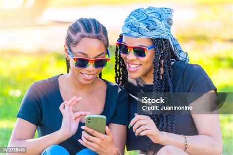 Afrolatinx Playful Young Lesbians Embracing In A Park Taking Selfies With Their Smart Phone