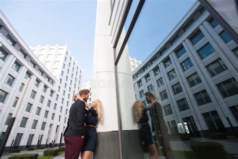 Guy Hugging A Girl In The City On The Background Of Buildings The Reflection In The Glass