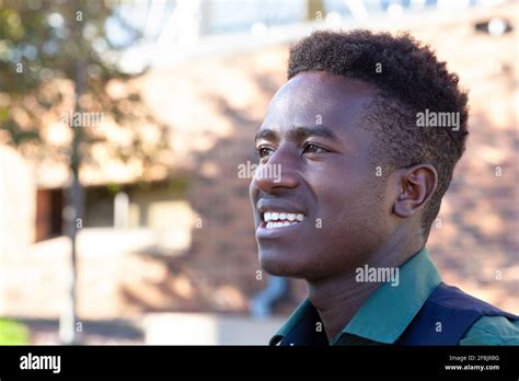 A Handsome Smiling Young Black Student Stands In Front Of His College