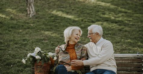 꽃으로 가득 찬 바구니를 들고 벤치에 앉아 포옹하는 잘생긴 노부부 사진 Unsplash의 노인 성인 이미지