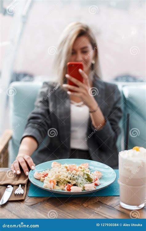 Beautiful Young Woman Eats And Takes Photo Food In A Restaurant Stock