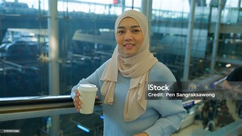 커피 한 잔을 들고 여행 가방을 끌고 공항의 에스컬레이터를 타고 올라가는 젊은 여성 관광객 25 29세에 대한 스톡 사진 및 기타 이미지 Istock