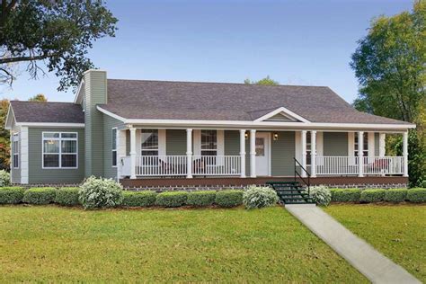Column Details And Bushes On Gray House In Lush Green Field
