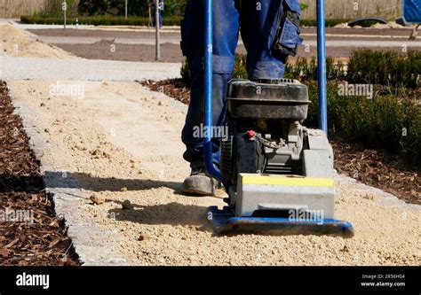 Legs And Feet Of A Man Who Operates A Sand Compactor The Man Is