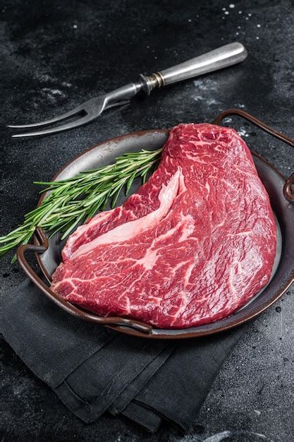 Premium Photo Raw Top Sirloin Beef Meat Steak In A Steel Tray With Rosemary Black Background