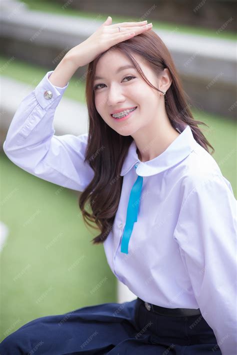 자신있게 앉아 그녀의 치아에 교정기와 교복에 아시아 고등학생 소녀 프리미엄 사진