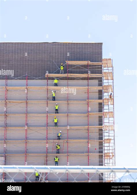 Unrecognizable Workers Removing Timber Planks From Scaffolding At A