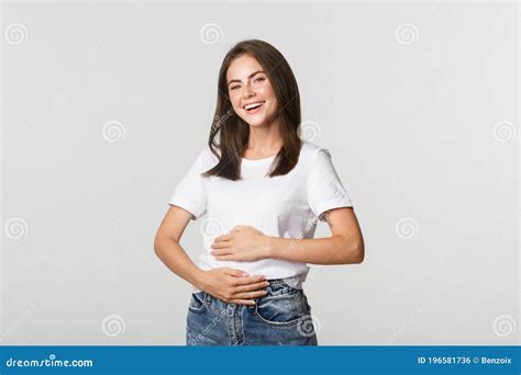 Satisfied Smiling Brunette Girl Rubbing Belly After Eating Delicious