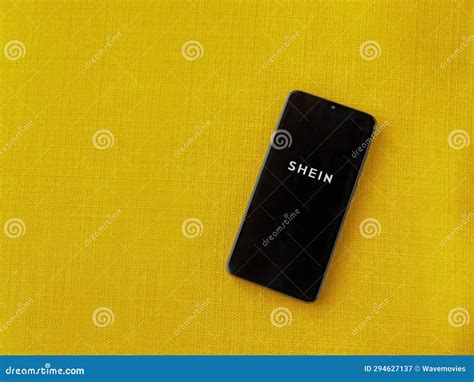 Shein App Launch Screen On Smartphone On Yellow Fabric Background