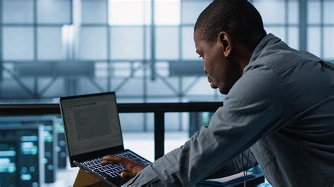 Technician In Data Center Using Programming Languages On Laptop Free