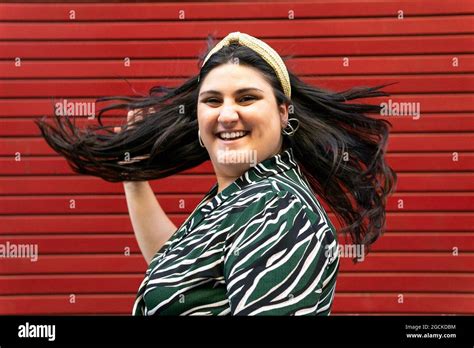 Side View Of Cheerful Young Curvy Brunette In Stylish Striped Outfit