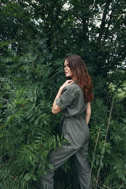 Premium Photo Portrait Of A Woman In Overalls Near Green Bushes Side
