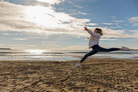 Uma Bela Jovem Enérgica Fazendo Ginástica Na Praia Foto Premium