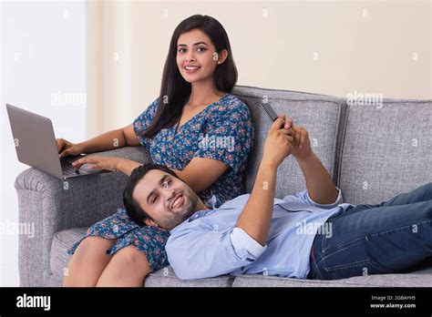 A Young Man Resting His Head On The Lap Of Woman While They Work On