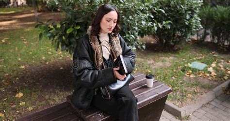 Woman Sits On Wooden Park Bench And Opens Paper Notebook Stock Footage