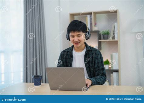 Smart Asian Man Wearing Headphone With Braces Smiling Working With Computer Laptop Work Form