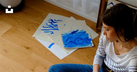 흰색 긴 소매 셔츠와 파란색 데님 청바지를 입은 여자 갈색 나무 테이블에 앉아 사진 Unsplash의 무료 예술 이미지