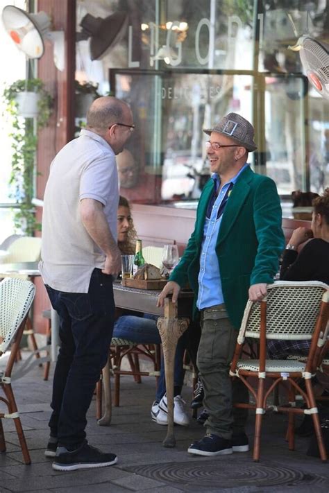 עומדים בבית קפה קובי אוז ואשתו מפגינים אהבה