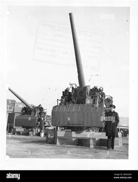 Photograph Of Military Individual Standing Near Manned Turret Guns