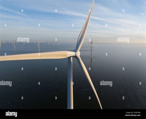 Wind Turbines At The Afsluitdijk On Water Converts The Kinetic Energy