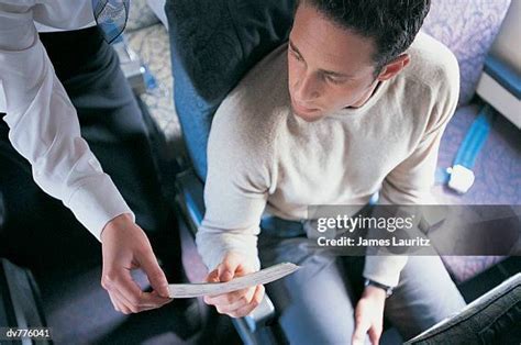 Male Passenger Showing His Ticket To An Air Stewardess On An Aeroplane
