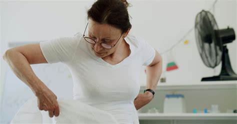 A Medium Shot Of An Elderly Woman Wearing A Ppe Suit In A Laboratory