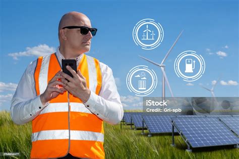 엔지니어 뒤에 발전소 태양 전지판을 가진 들판에 있는 남자 재생 에너지용 풍력 터빈 자연을 소중히 여기는 전기를 얻습니다 에너지