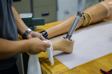 Male Worker Assembling Parts Of Artificial Leg In Prosthetic Workshop