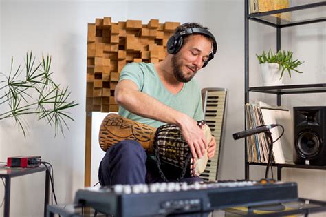 집에서 디지털 스튜디오에서 젬 베 드럼 악기를 녹음 전문 음악가 그는 악기와 Midi 컨트롤러로 둘러싸여 있습니다 음악 제작