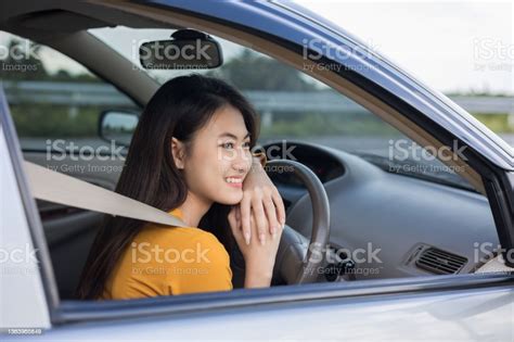 젊은 아름다운 아시아 여성은 새로운 차를 받고 그녀는 매우 행복하고 흥분했다 그녀는 앉아서 자동차의 모든 세부 사항을 만지고