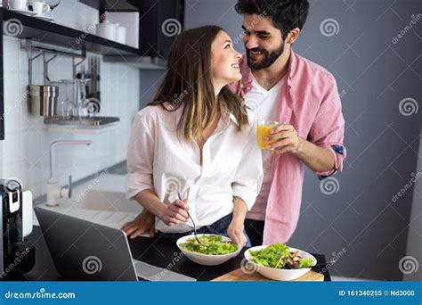 Hermosa Pareja Joven Y Juguetona Comiendo Ensalada Juntos En Casa Imagen De Archivo Imagen De