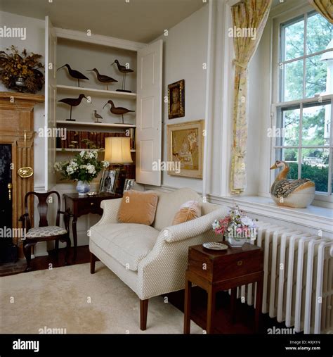 Small White Sofa In Front Of Radiator In Townhouse Sitting Room With Decoy Duck Collection On
