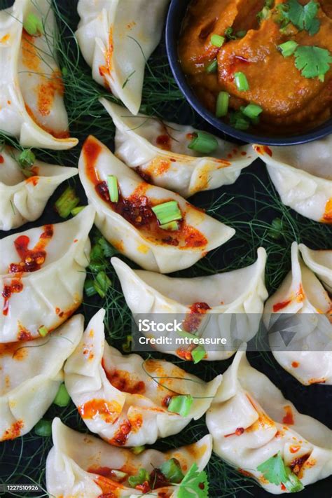 찐 모모 닭고기와 혼합 야채로 채워진 흰 밀가루와 물 반죽 칠리 오일 회향 침대에 뿌려 다진 파와 고수 잎으로 장식 한 풀 프레임 이미지 높은 전망 식용유에 대한 스톡 사진