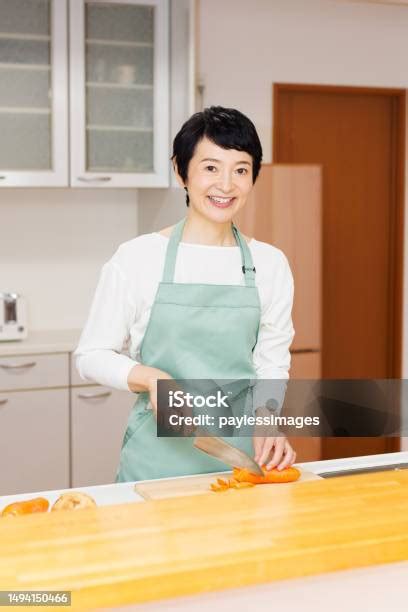 Mature Japanese Woman Doing Food Preparation At Kitchen 照片檔及更多 一個人 照片 Istock