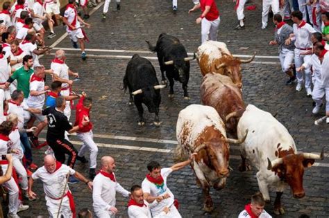 Daredevils Run With Charging Bulls At Pamplonas San Fermín Festival