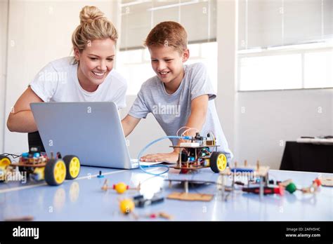 Male Student With Teacher Building Robot Vehicle In After School Computer Coding Class Stock