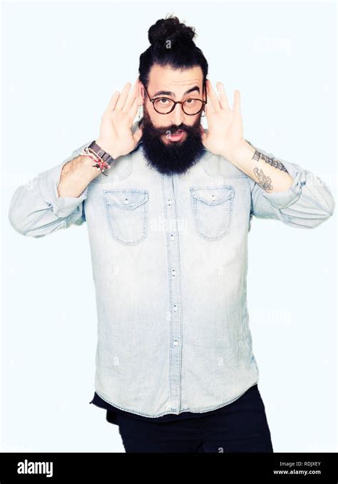 Young Hipster Man With Long Hair And Beard Wearing Glasses Trying To