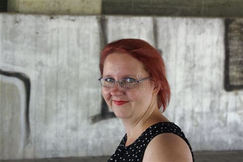 A Woman With Red Hair And Glasses Is Smiling At The Camera Stock Image