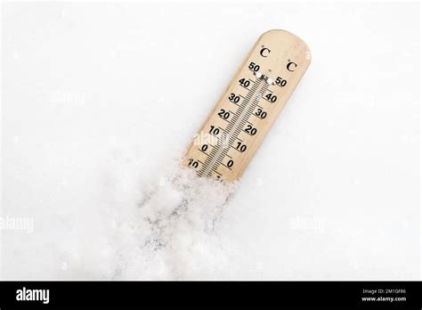 Wooden Thermometer On Snow Shows Low Temperature Below Zero In Celsius Degrees Scale Winter