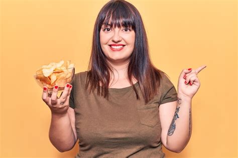 Premium Photo Young Plus Size Woman Holding Potato Chip Smiling Happy