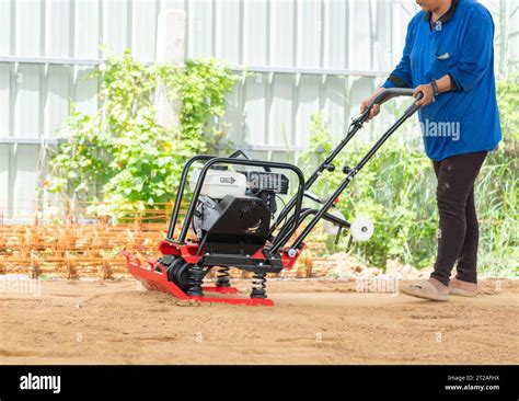 Worker In Use Vibratory Plate Compactor For Compaction Sand In