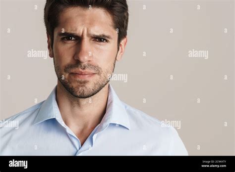Portrait Of Unshaven Displeased Man Posing And Looking At Camera Isolated Over White Background