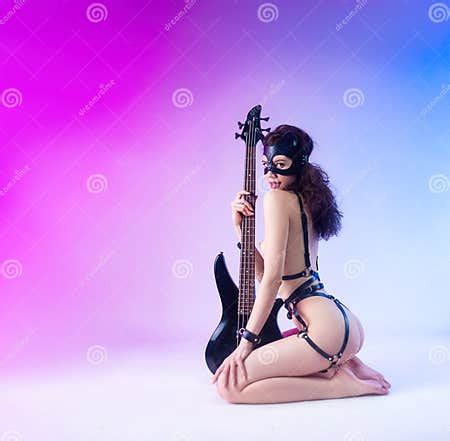 Naked Woman In Bdsm Harness And Mask With Bass Guitar On The Floor In