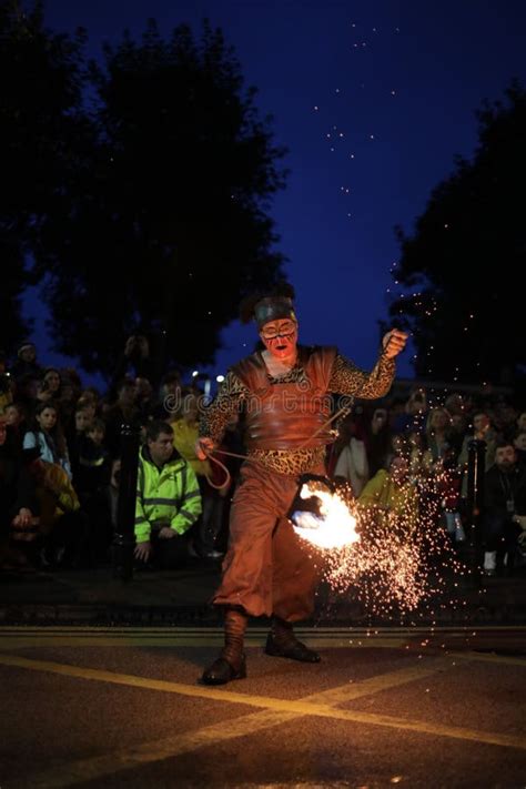 Male Wearing A Colorful Costume And Holding A Flaming Prop Performing A
