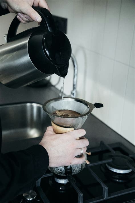 A Person Pouring Something Into A Bowl On A Stove Photo Free Kitchen