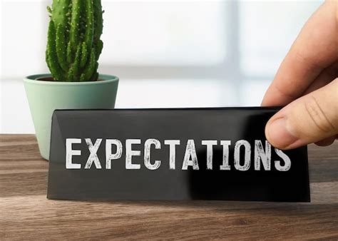 Premium Photo A Hand Is Holding A Black Desk Sign That Says Expectations