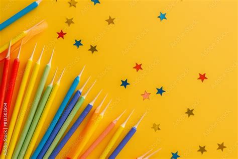 The Flag On A Stick And Rainbow Candy Stars Lay Flat On A Yellow Background With Copy Space In