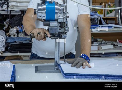 Worker Using A Cutter A Large Machine For Cutting Fabrics In A