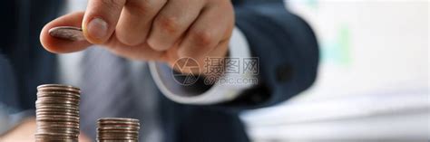 男手握桌上的西装堆叠硬币高清图片下载 正版图片503987522 摄图网